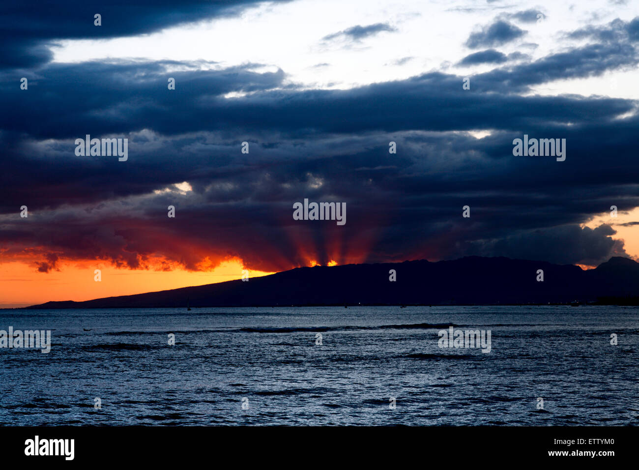 Honolulu, Hawaii. 12th Jun, 2015. Orange sun rays shining from behind ...