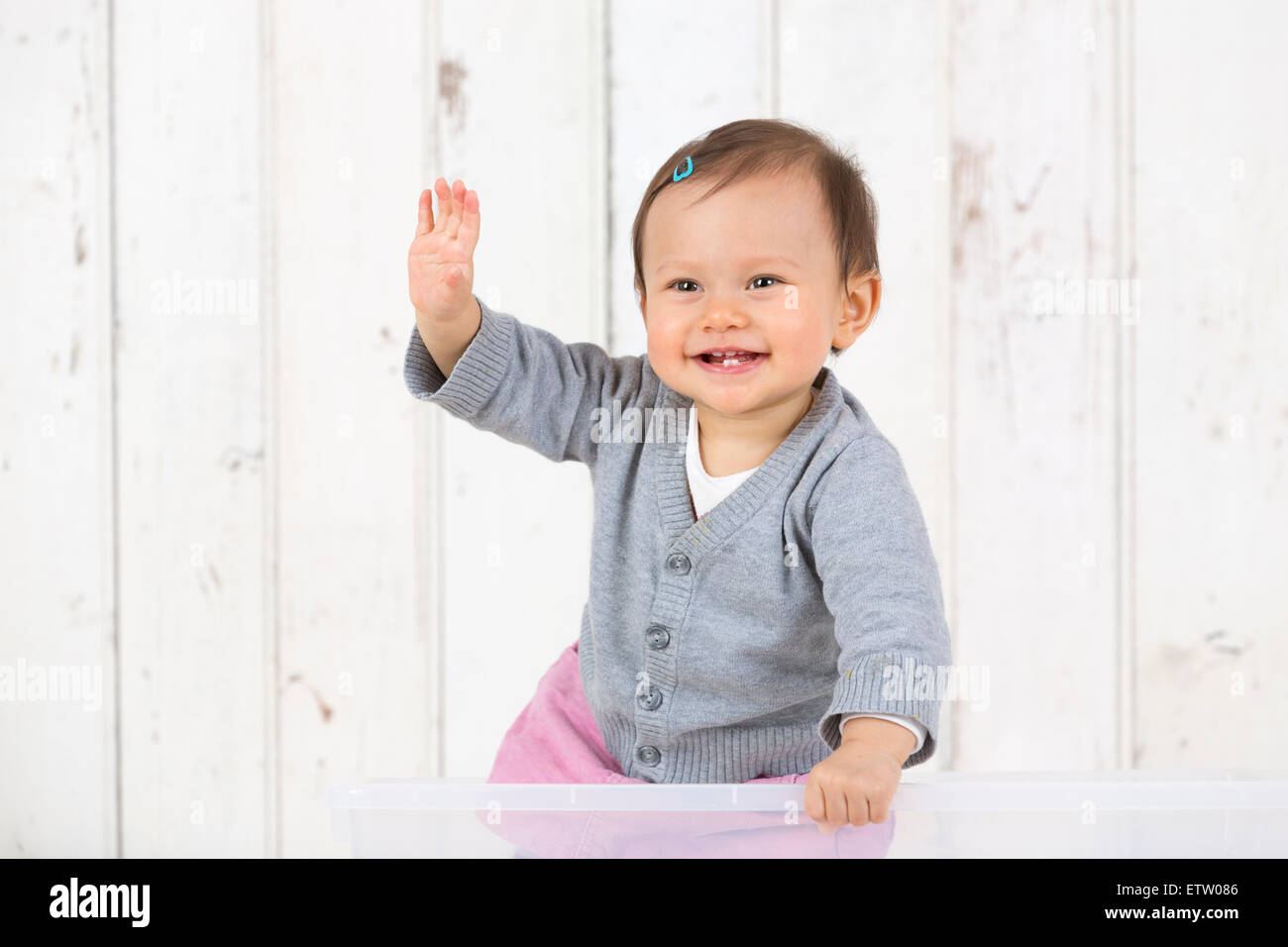 Laughing little girl waving hand Stock Photo - Alamy