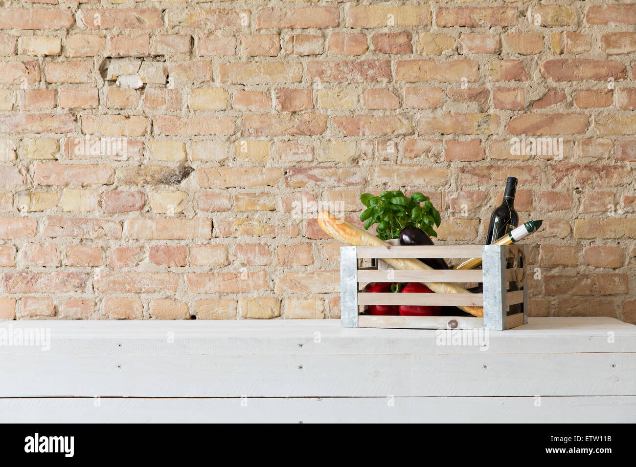 Wooden box with vegetables, pasta, baguette, basil and wine bottle ...