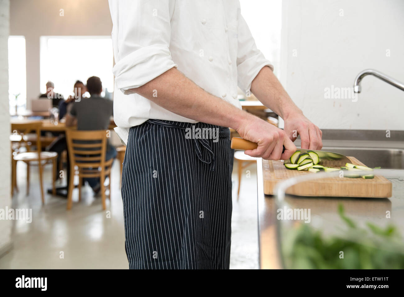 Cook of a bistro preparing food in the kitchen Stock Photo - Alamy