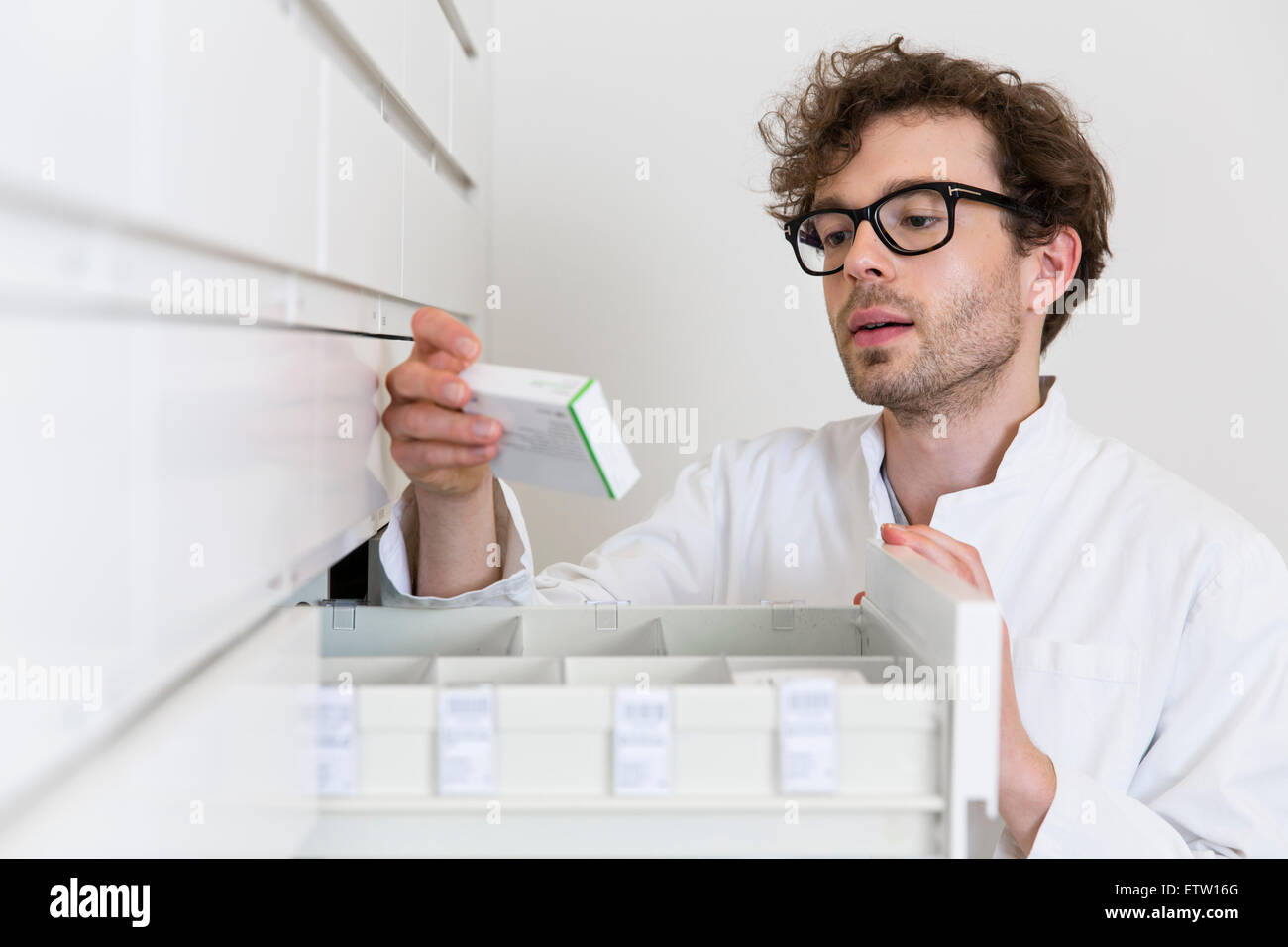 Pharmacist taking drug from a drawer cabinet Stock Photo - Alamy
