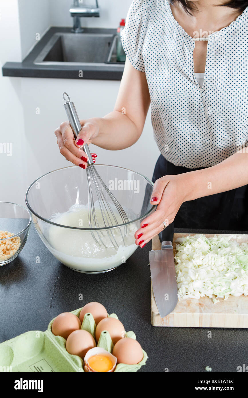Woman stirring dough in a glassbowl with wire whisk Stock Photo - Alamy