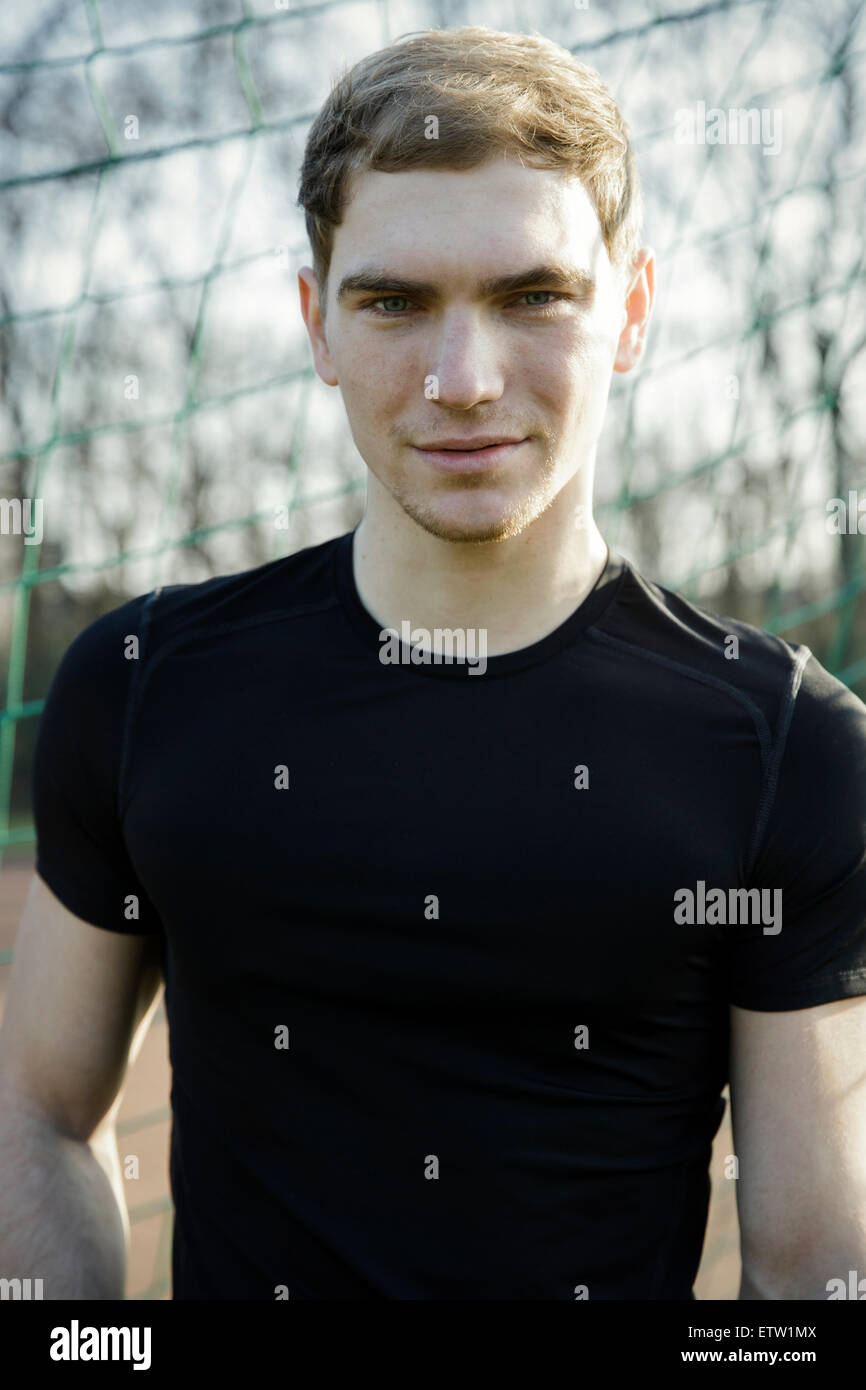 Portrait of young man standing in soccer goal Stock Photo - Alamy