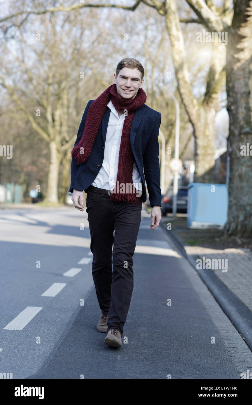 Portrait of smiling young man walking on street Stock Photo - Alamy