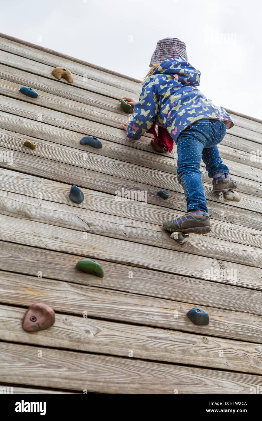 Little girl moving on climbing wall Stock Photo - Alamy