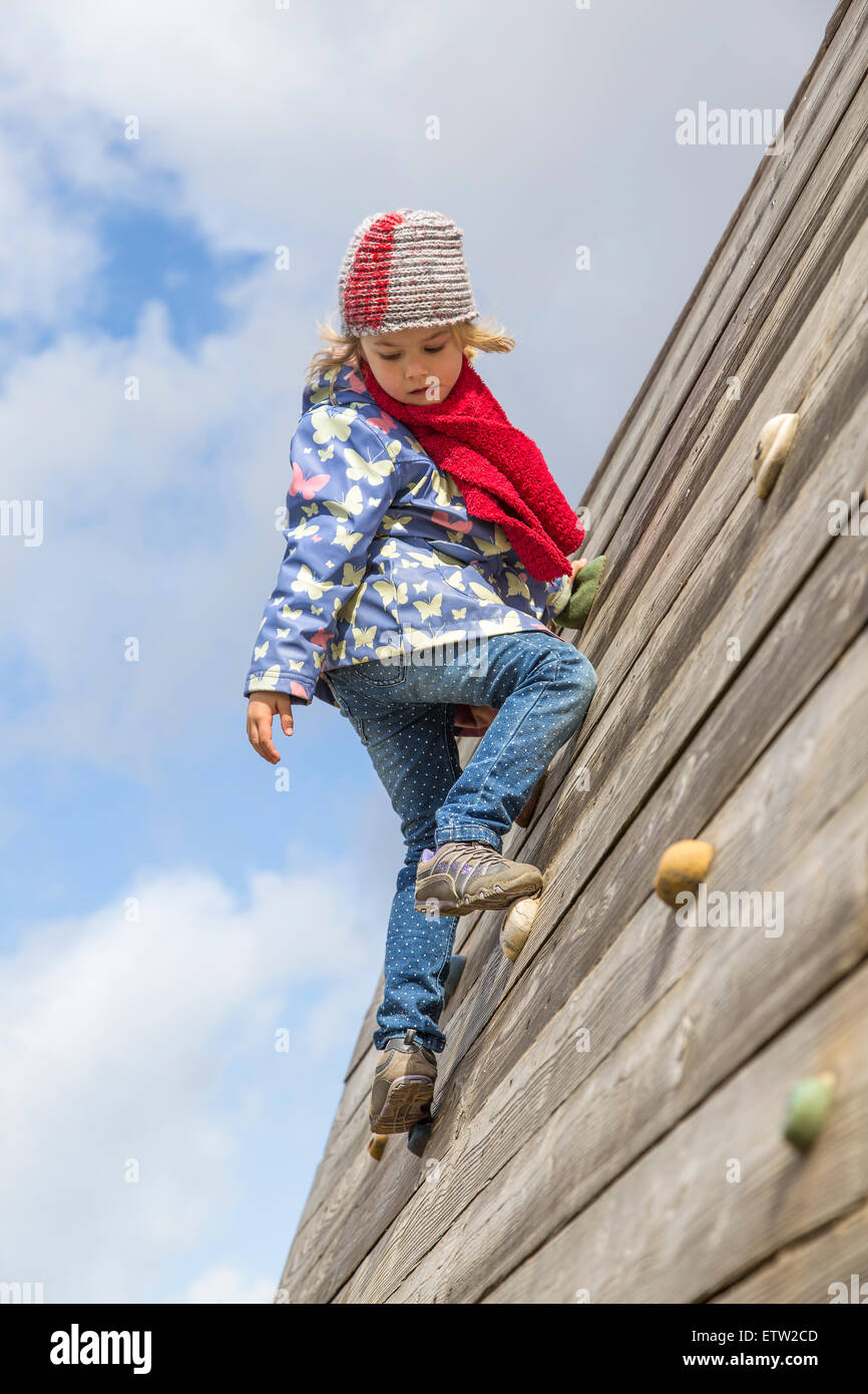 Little girl moving on climbing wall Stock Photo - Alamy
