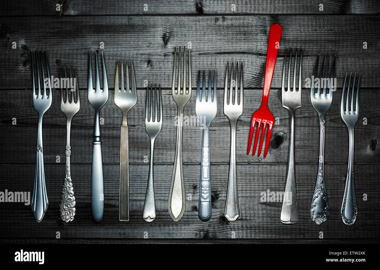 Row of different silver forks and a red plastic fork on wood Stock ...