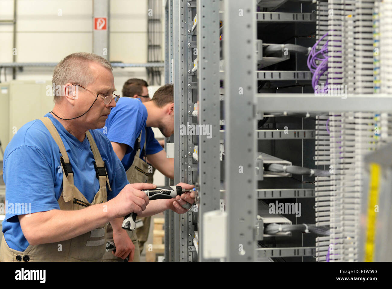 Workers in a switchboard construction factory Stock Photo - Alamy