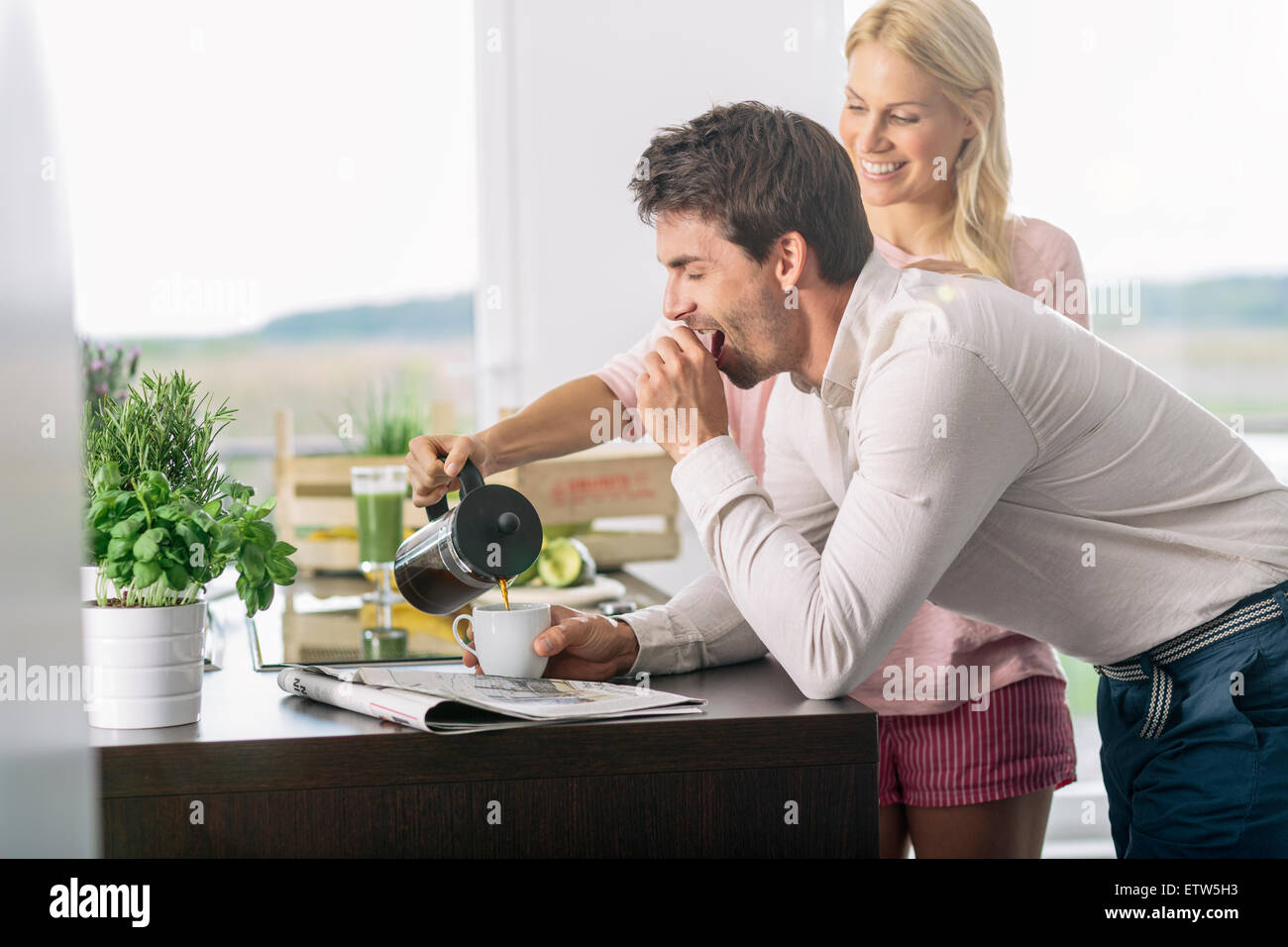 Woman pouring coffee in the cup of her boyfriend Stock Photo - Alamy