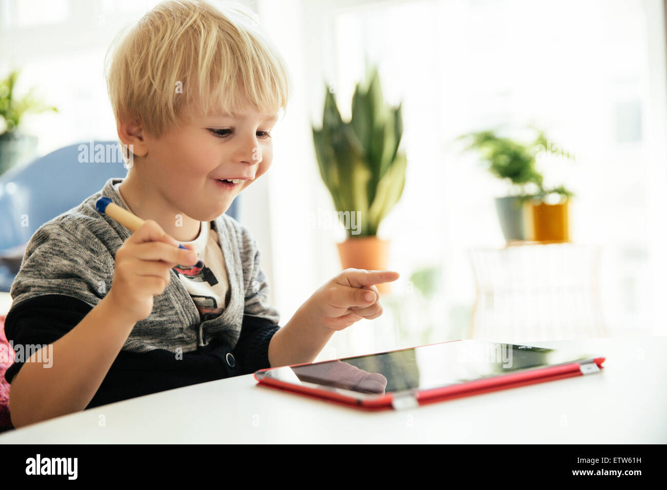 Happy little boy with digital pen and digital tablet at home Stock ...