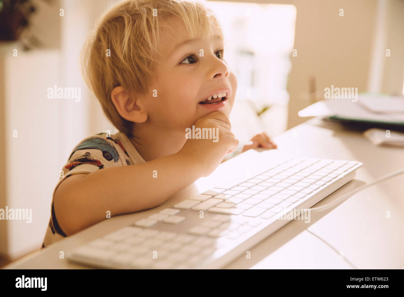 Smiling little boy looking at the screen of a computer Stock Photo - Alamy