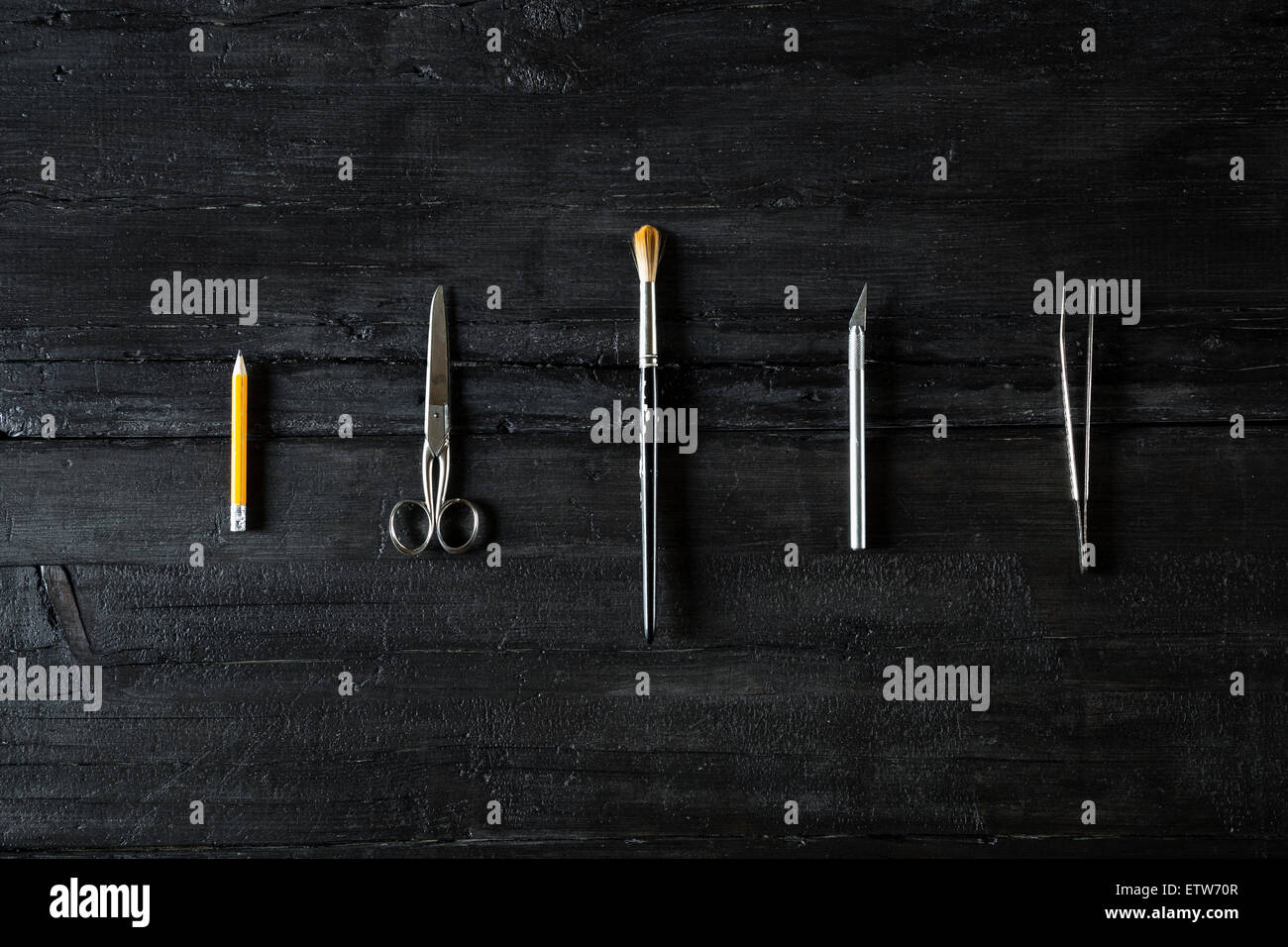 Row of different tools on black wood Stock Photo - Alamy
