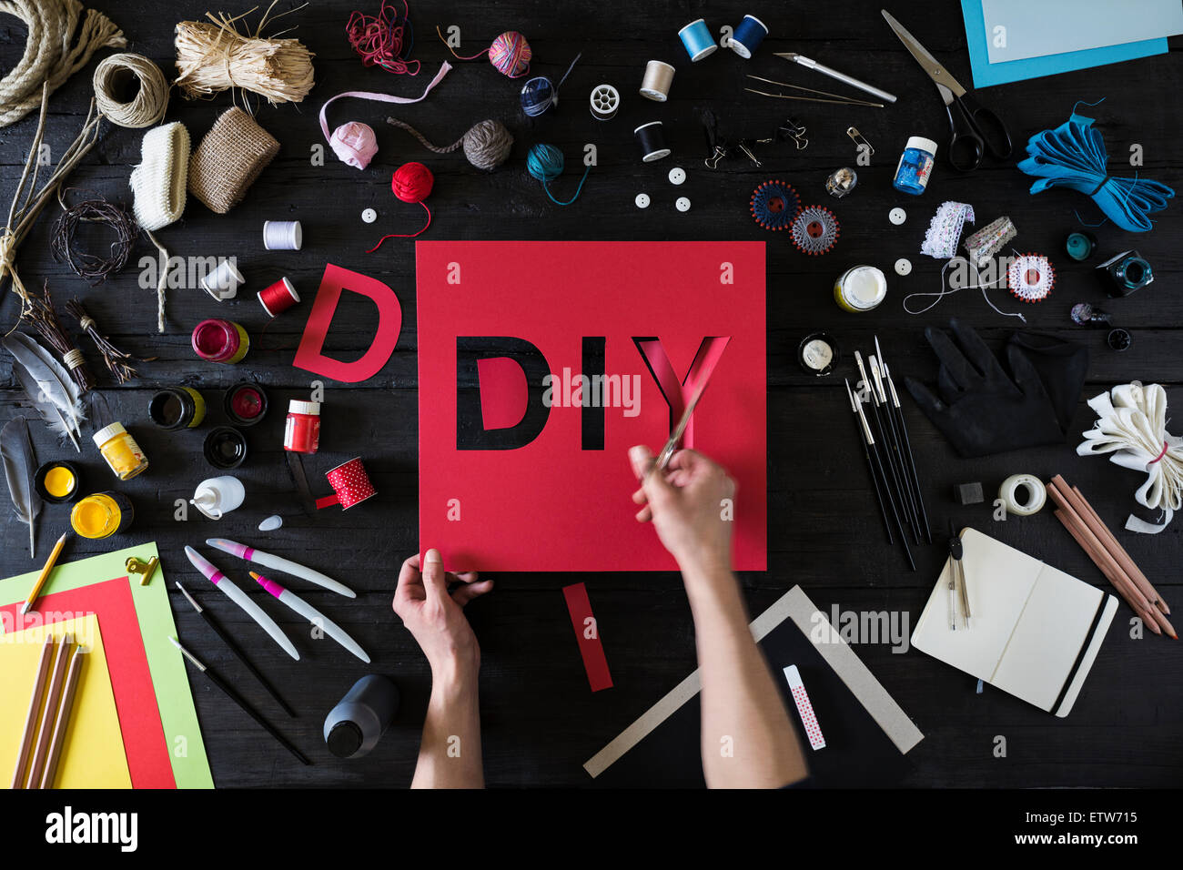 Man's hands cutting out the word DIY of red cardboard Stock Photo - Alamy