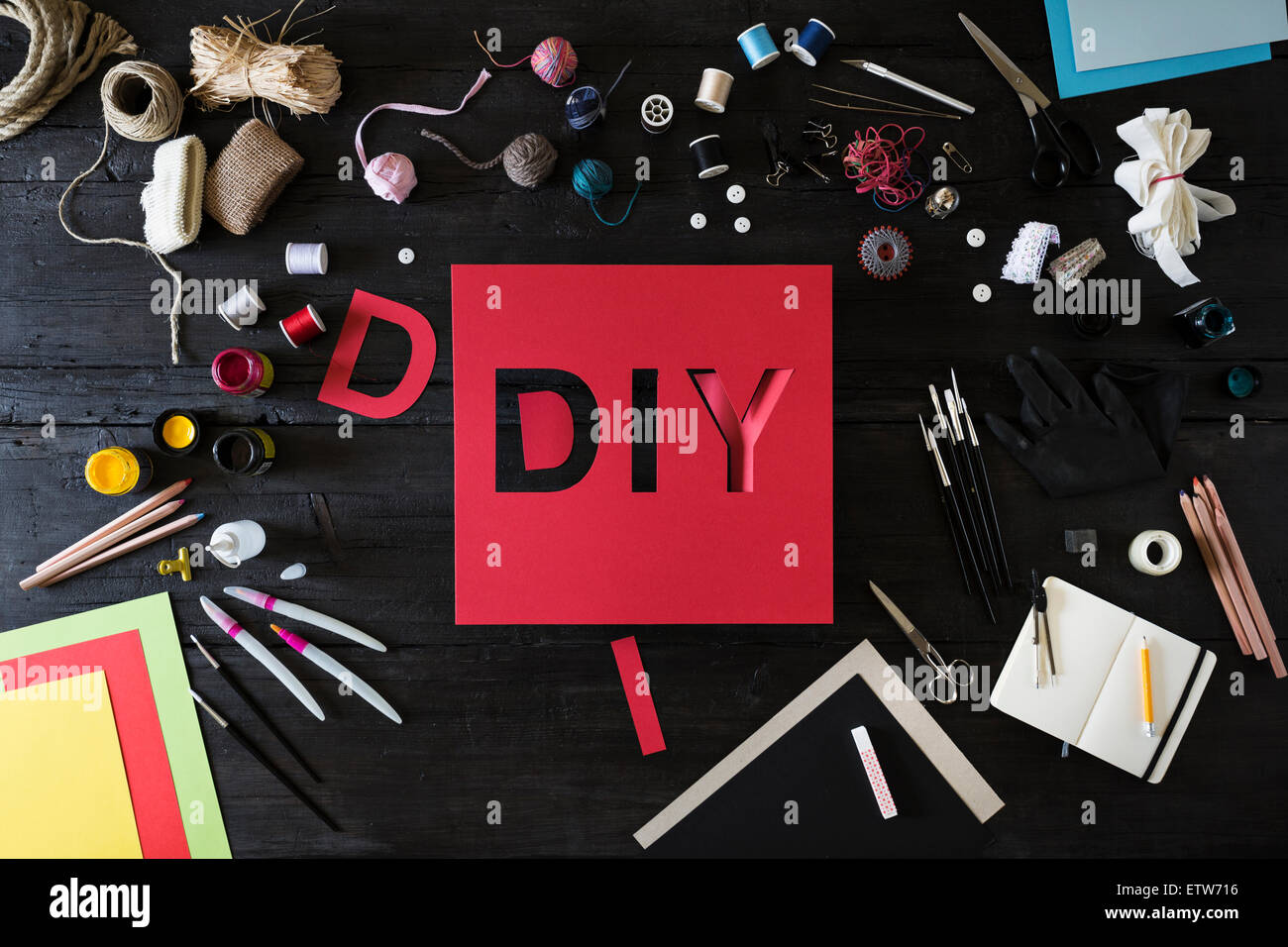 Craft materials, tools and red cardboard with the word DIY on black ...