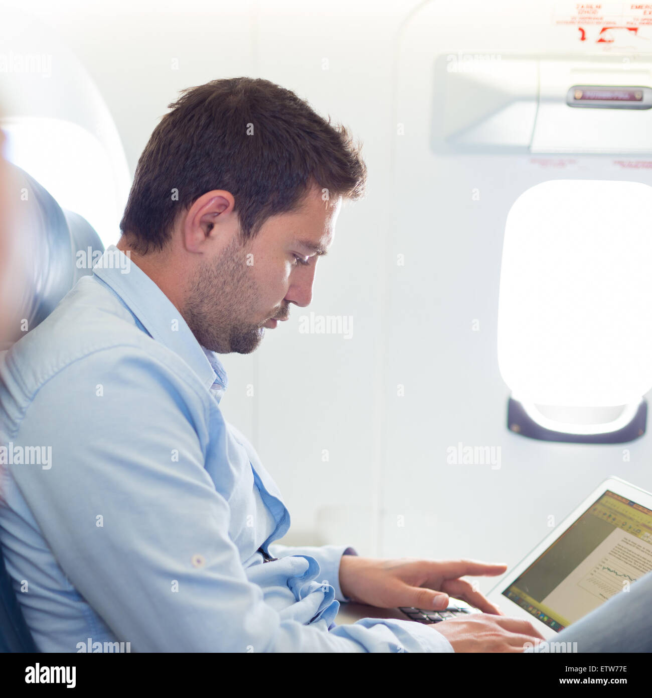 Businessman working with laptop on airplane Stock Photo - Alamy