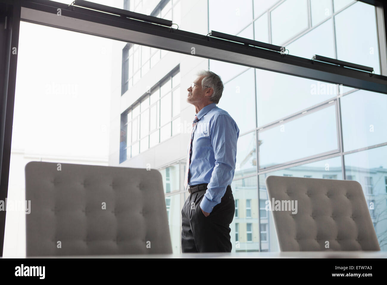 Successful manager standing at window in conference room Stock Photo ...
