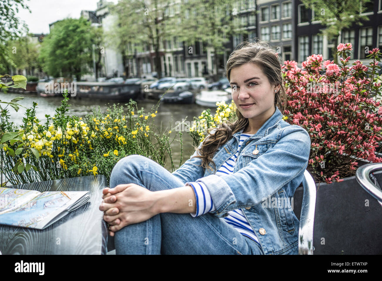 Netherlands, Amsterdam, portrait of female tourist having a rest in a ...