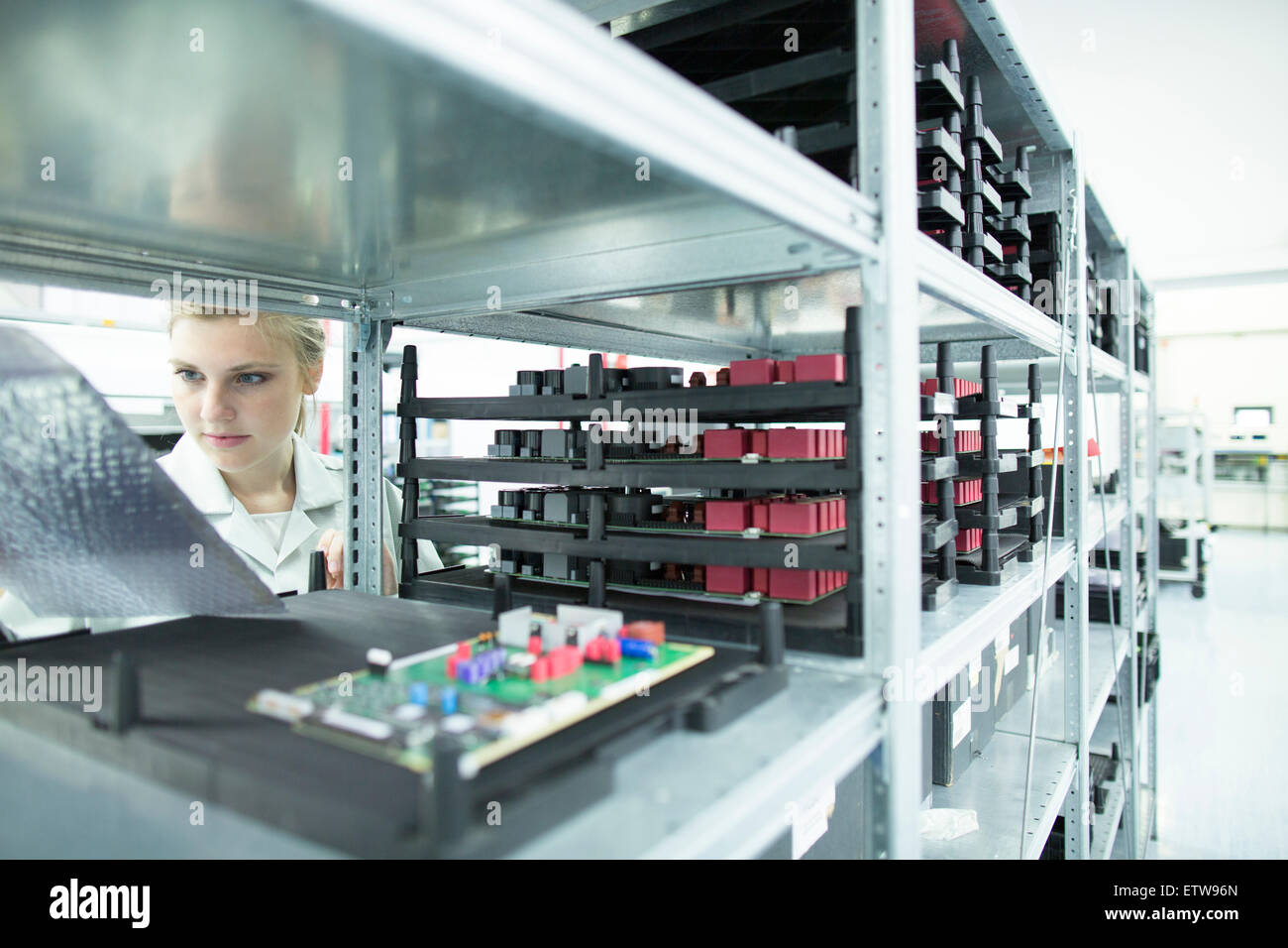 Technician at shelf with circuit boards Stock Photo - Alamy