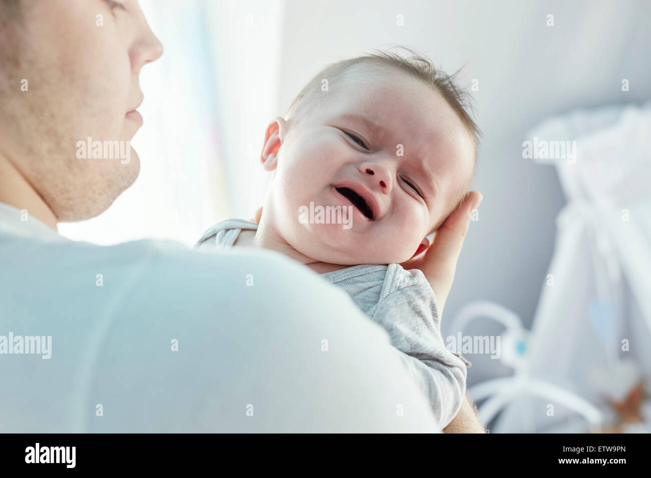 Young father consoling crying baby Stock Photo - Alamy