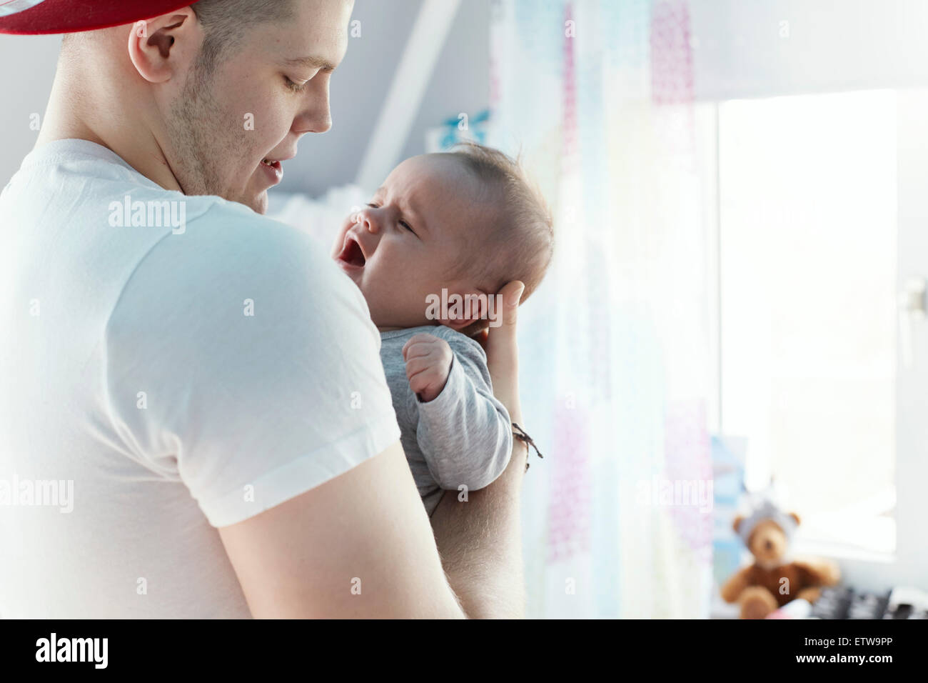 Young father consoling crying baby Stock Photo - Alamy