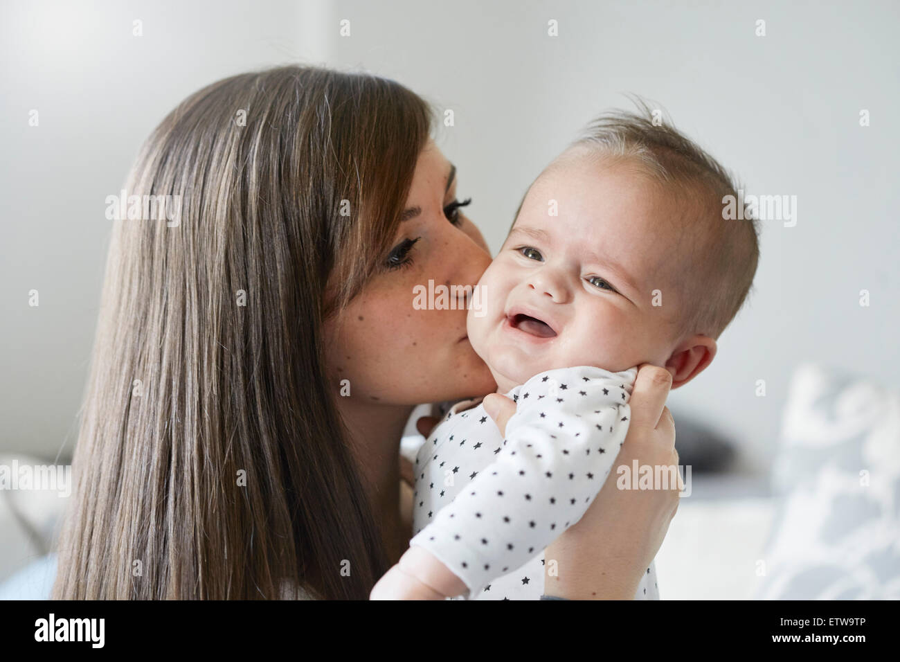 Young mother consoling crying baby Stock Photo - Alamy