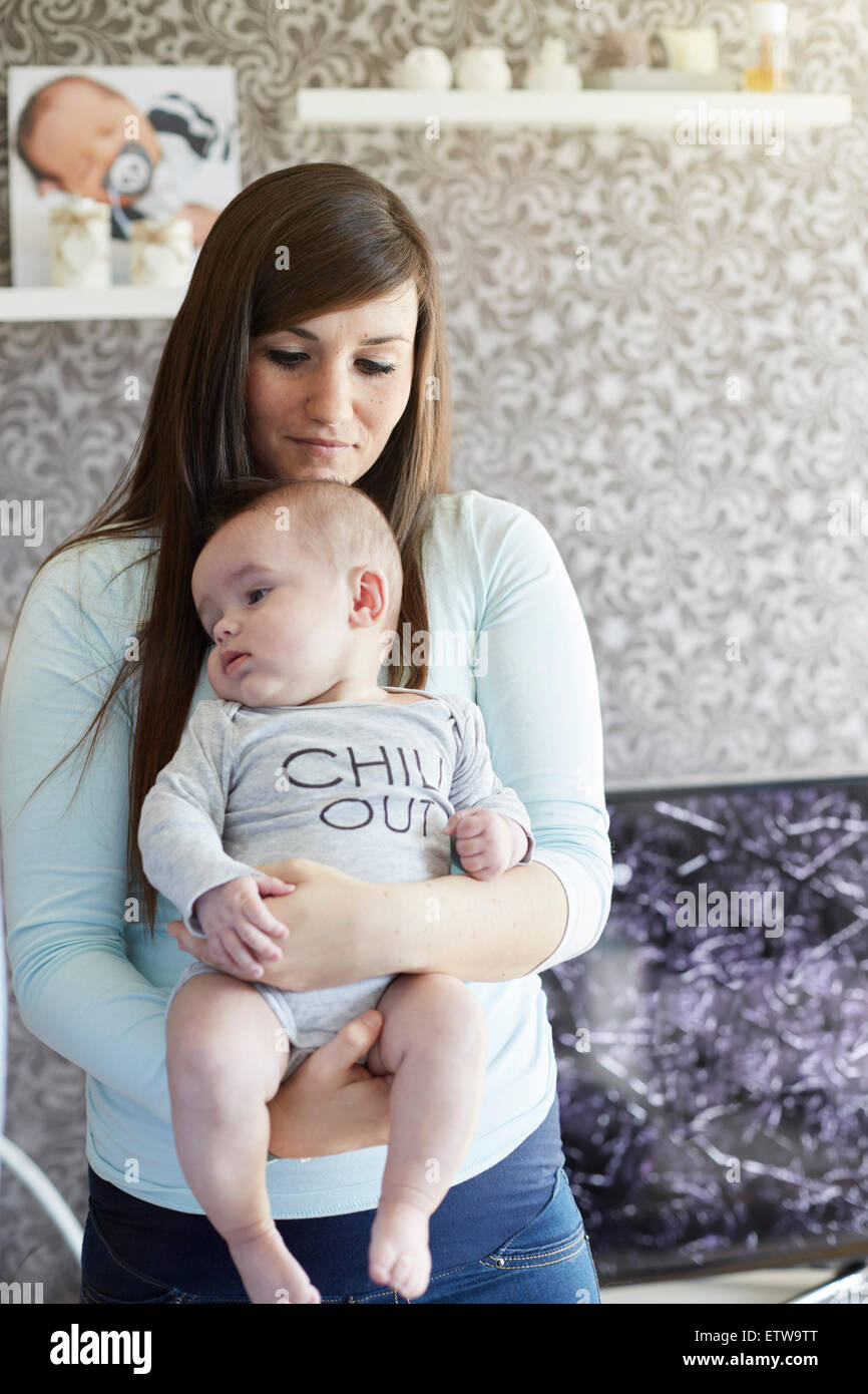 Young mother holding baby at home Stock Photo - Alamy