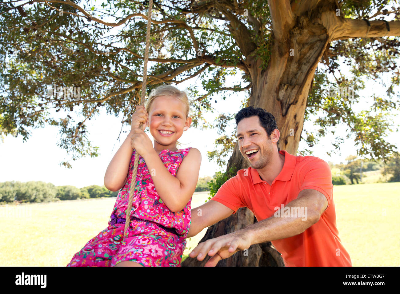 Father playing with daughter at rope swing Stock Photo - Alamy