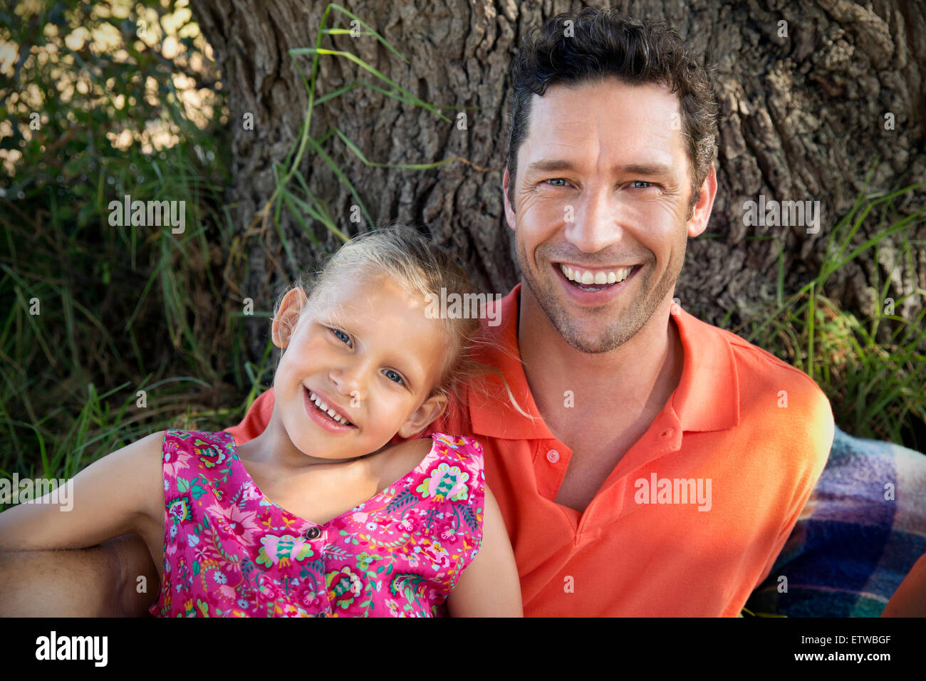 Portrait of happy father with daughter at tree Stock Photo - Alamy