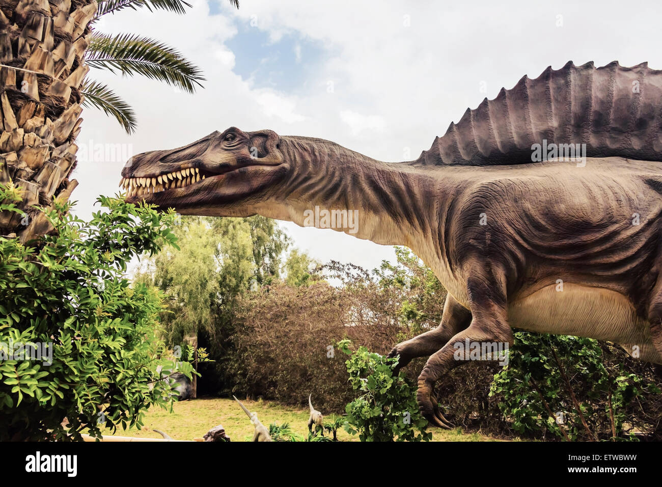 ancient extinct dinosaur spinosaurus on a background of plants Stock ...