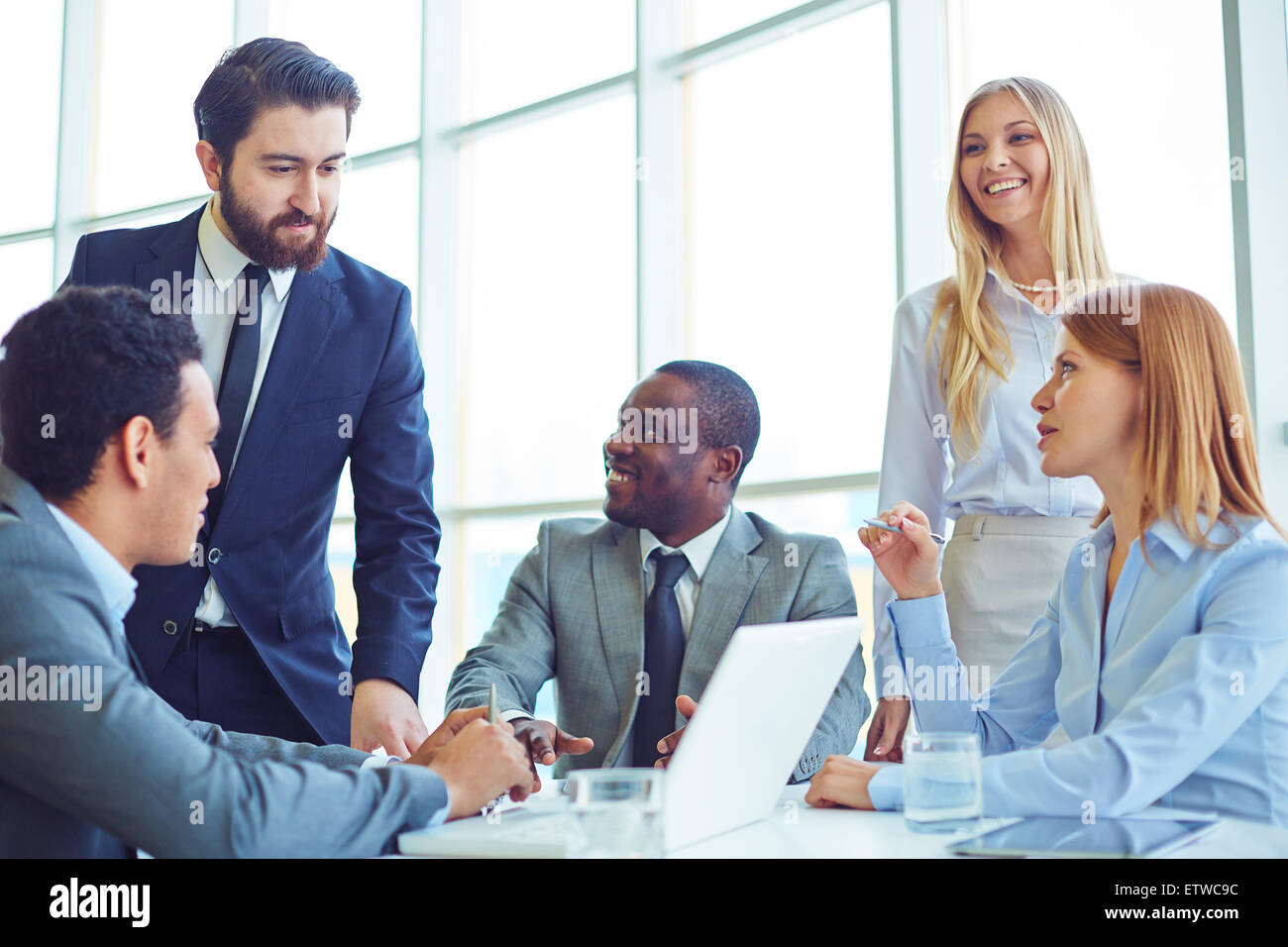 Group of employees looking at elegant businessman at meeting Stock ...