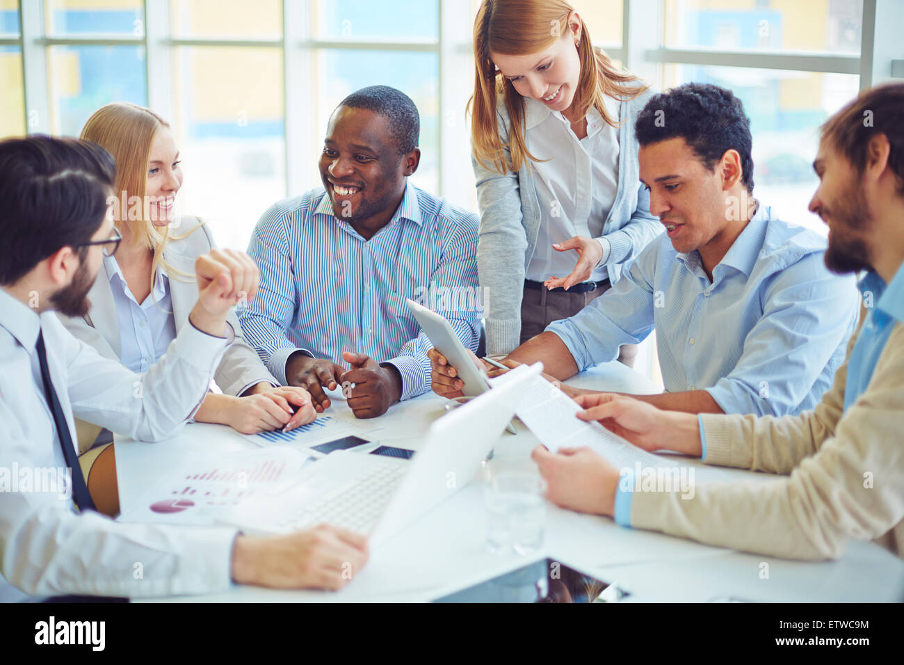 Group of happy colleagues communicating in office Stock Photo - Alamy