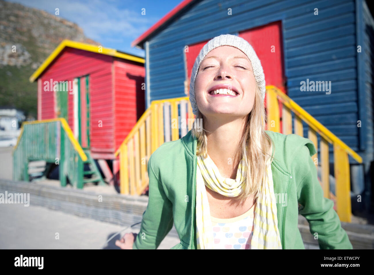 Happy young woman in front of colorful beach huts Stock Photo - Alamy