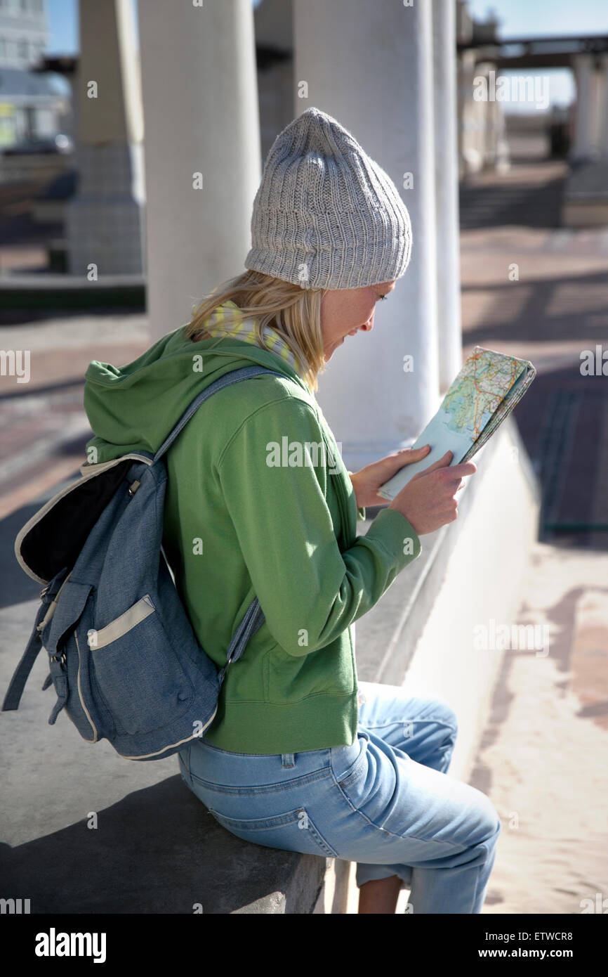 Tourist sitting on promenade reading map Stock Photo - Alamy