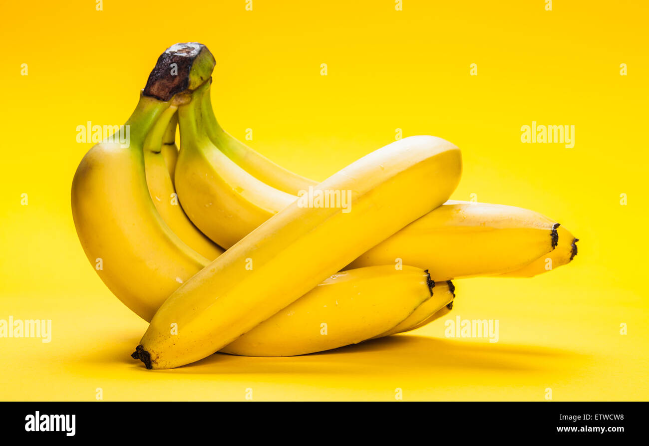 bunch of ripe bananas closeup on a yellow background Stock Photo - Alamy