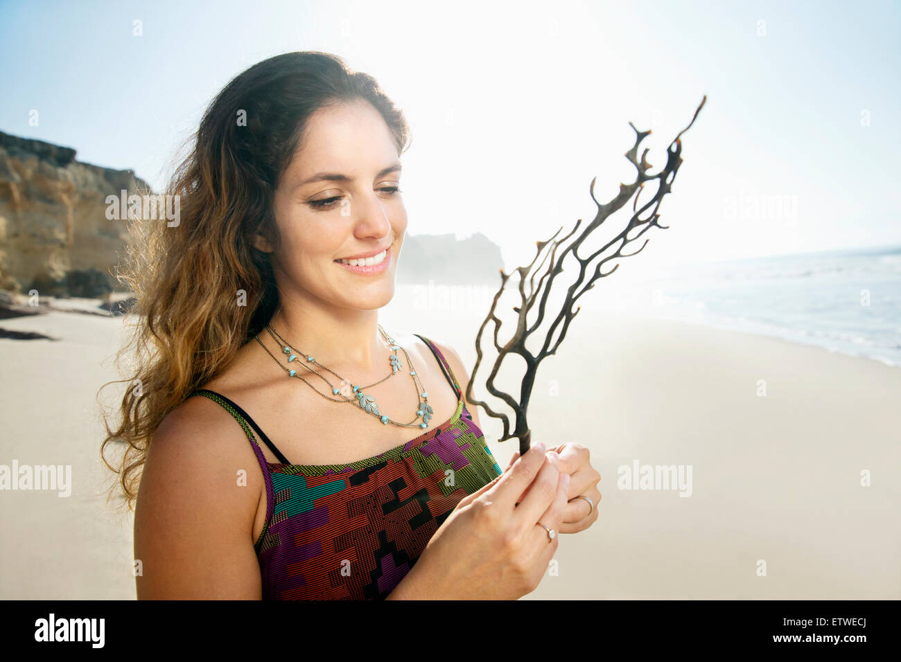 South Africa, smiling woman on the beach holding twig Stock Photo - Alamy