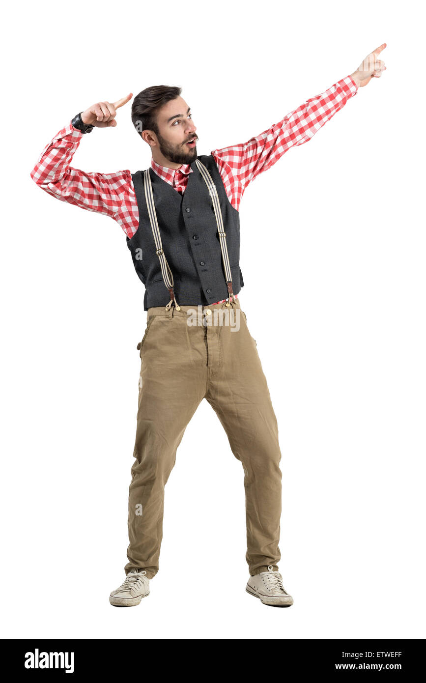 Excited young hipster winner pointing up celebrating. Full body length ...