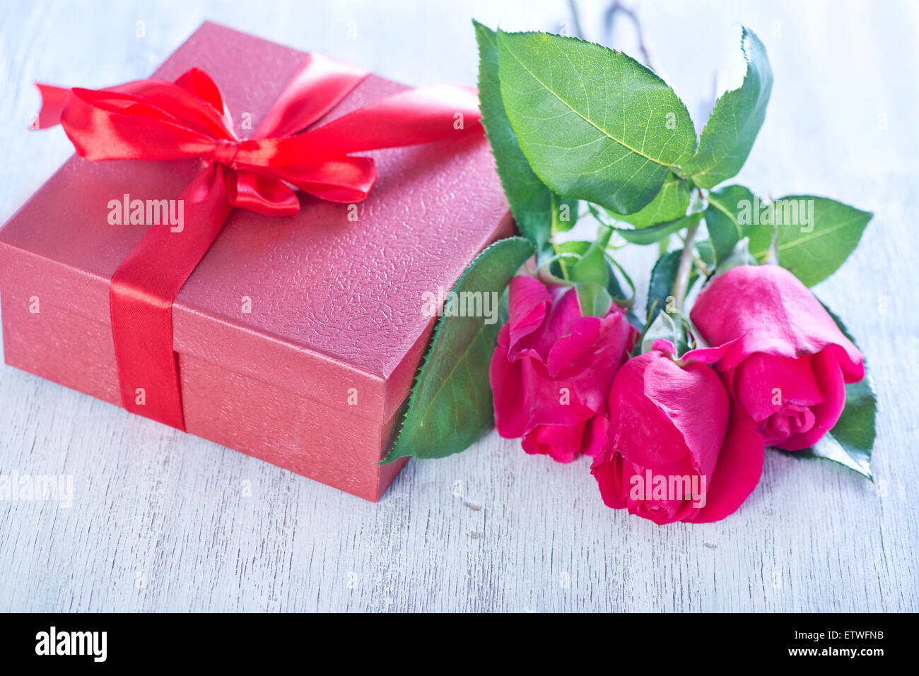 box for present and red roses on a table Stock Photo - Alamy