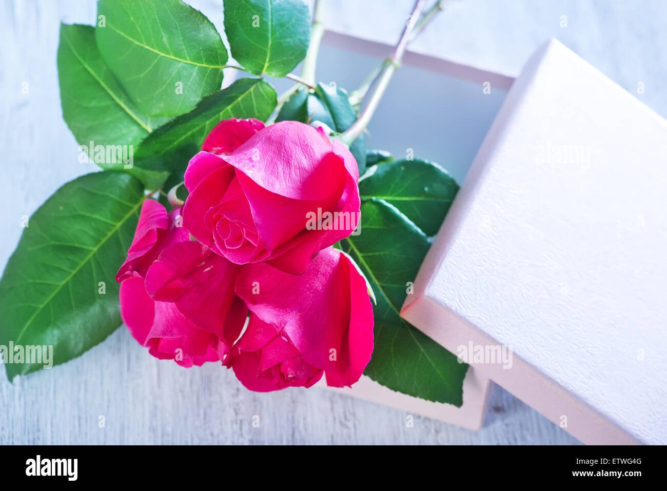 box for present and red roses on a table Stock Photo - Alamy