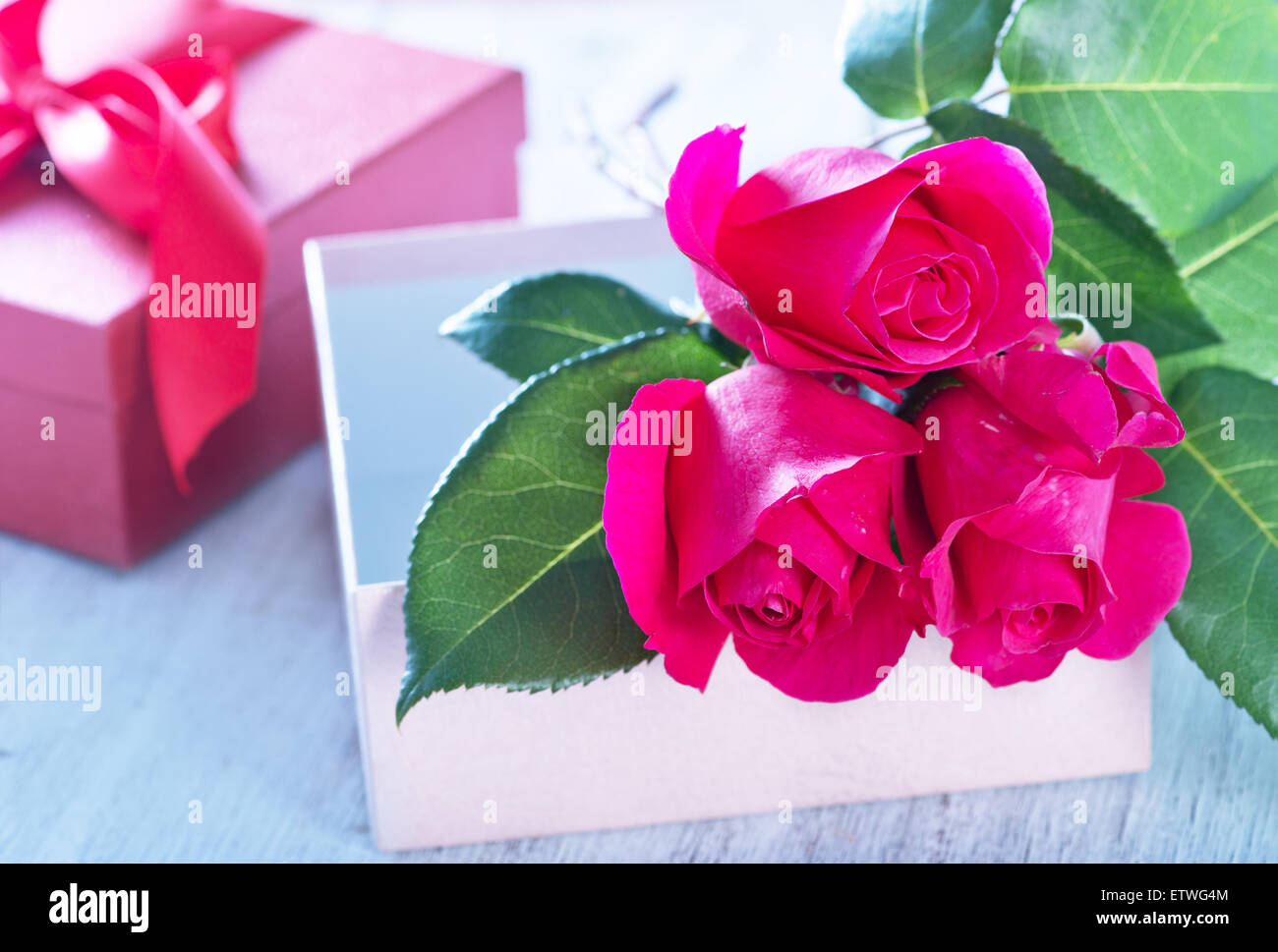 box for present and red roses on a table Stock Photo - Alamy
