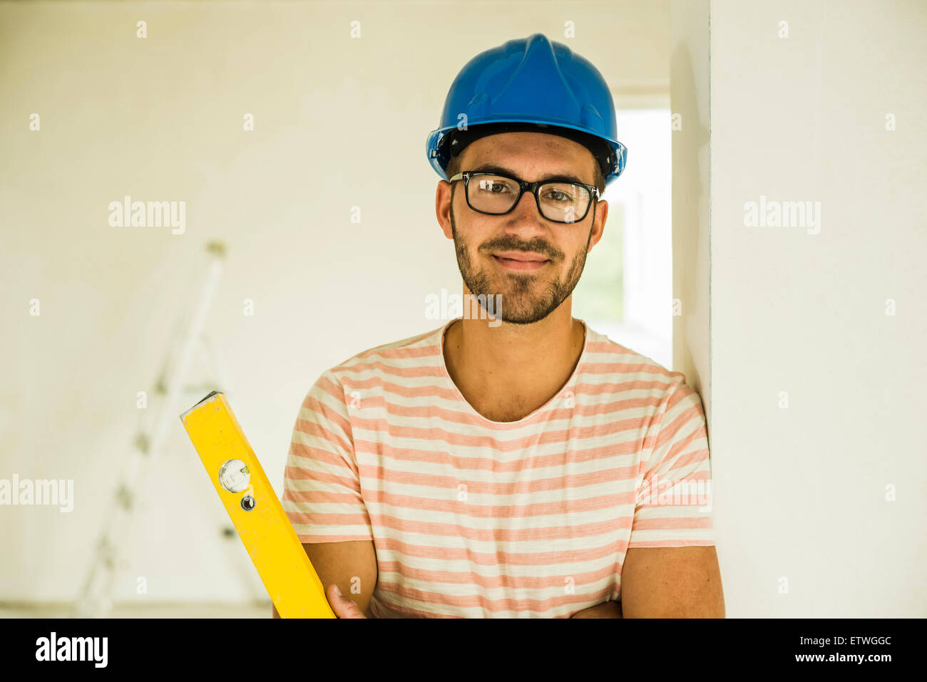 Portrait of smiling young man wearing hard hat Stock Photo - Alamy