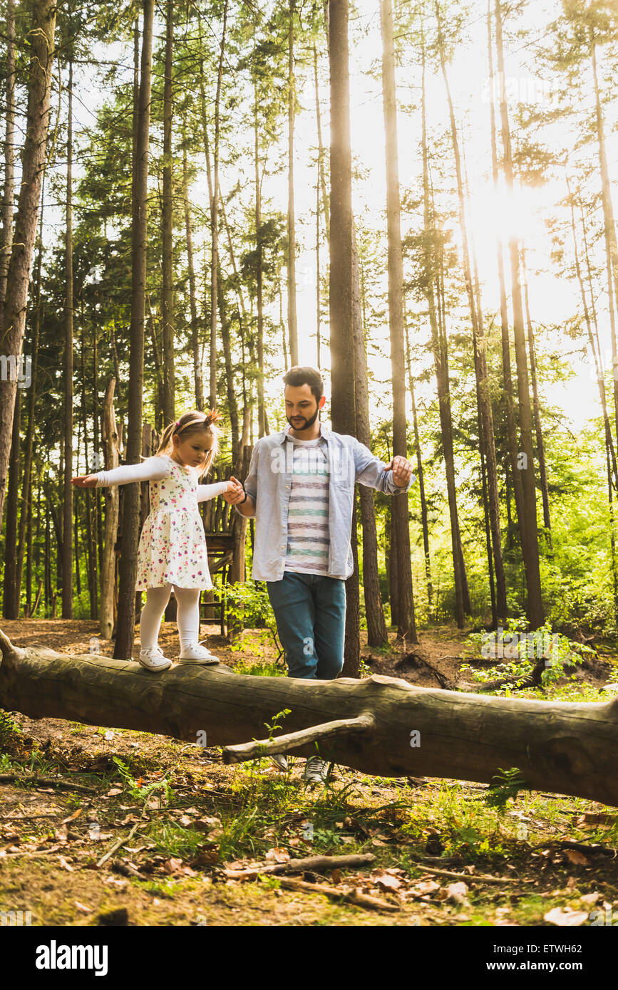 Father helping girl balancing on log Stock Photo - Alamy