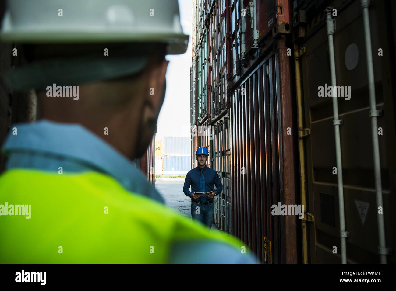Two men with safety helmets at container port Stock Photo - Alamy