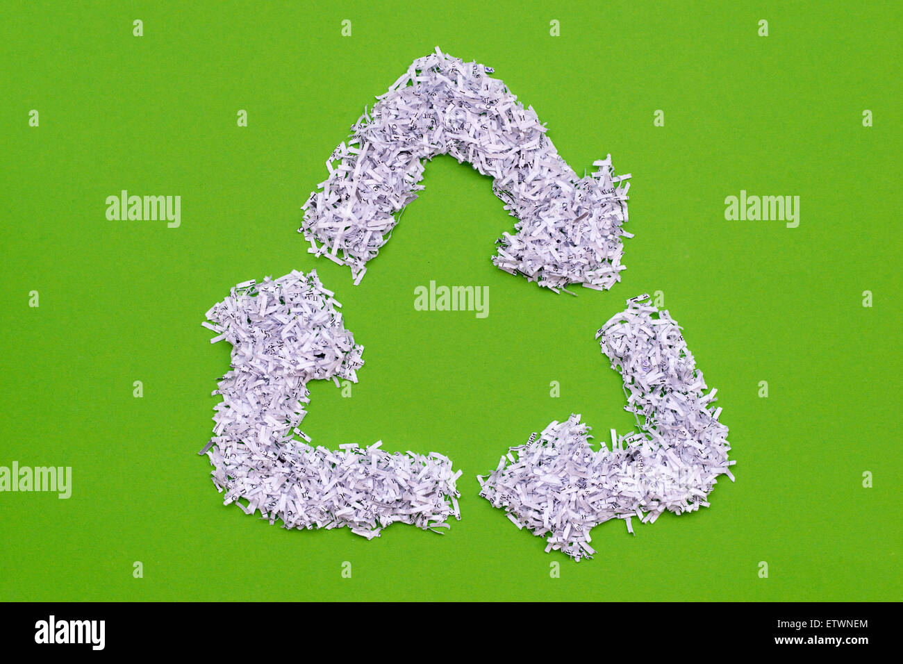 recycle symbol made from heap of shredded white paper over green Stock ...