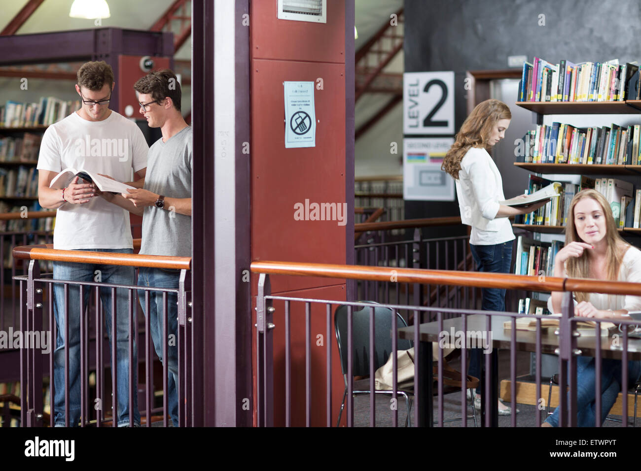 Four students in a library Stock Photo - Alamy