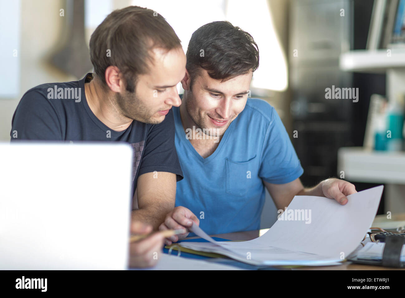 Two men with laptop and documents Stock Photo - Alamy