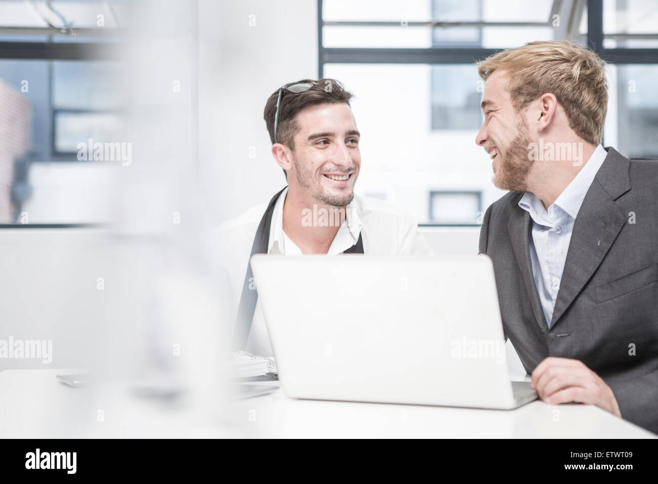 Two smiling businessmen having an office meeting Stock Photo - Alamy