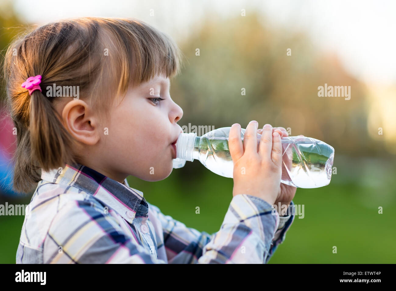 Girl drinking Water. Portrait of cute little girl drinking water outdoor - very shallow depth of ...