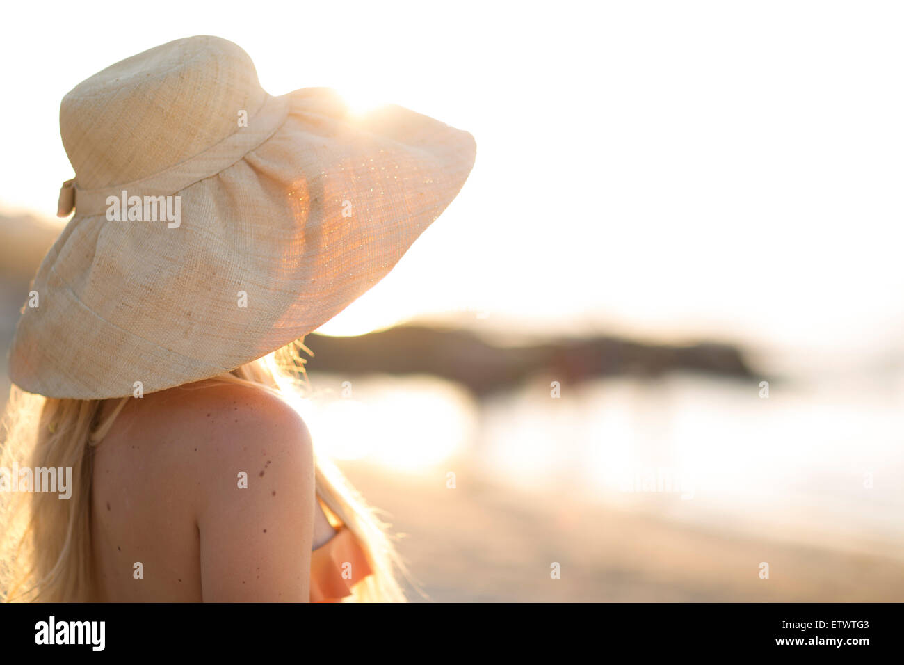Young woman wearing summer hat on the beach Stock Photo - Alamy