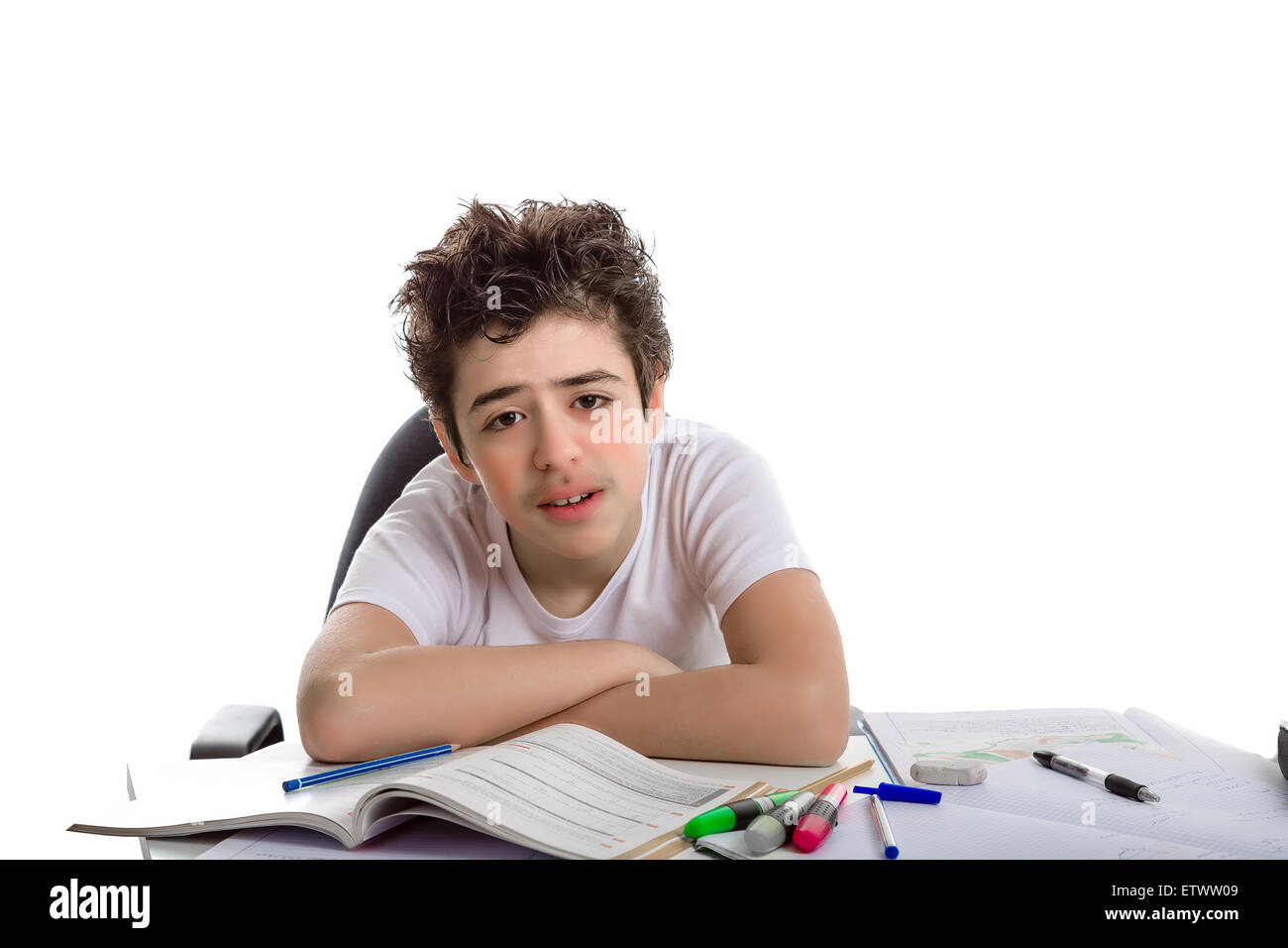 Tired boy doing his homework: he is crossing his arms on desktop ...