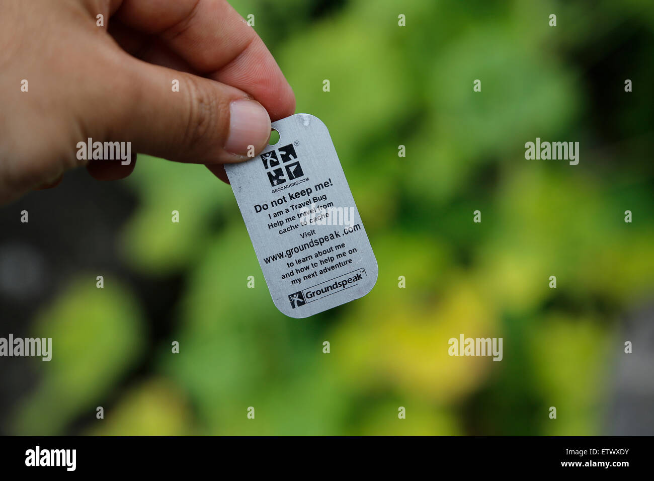 geocaching travelbug in the hand of geocacher Stock Photo - Alamy